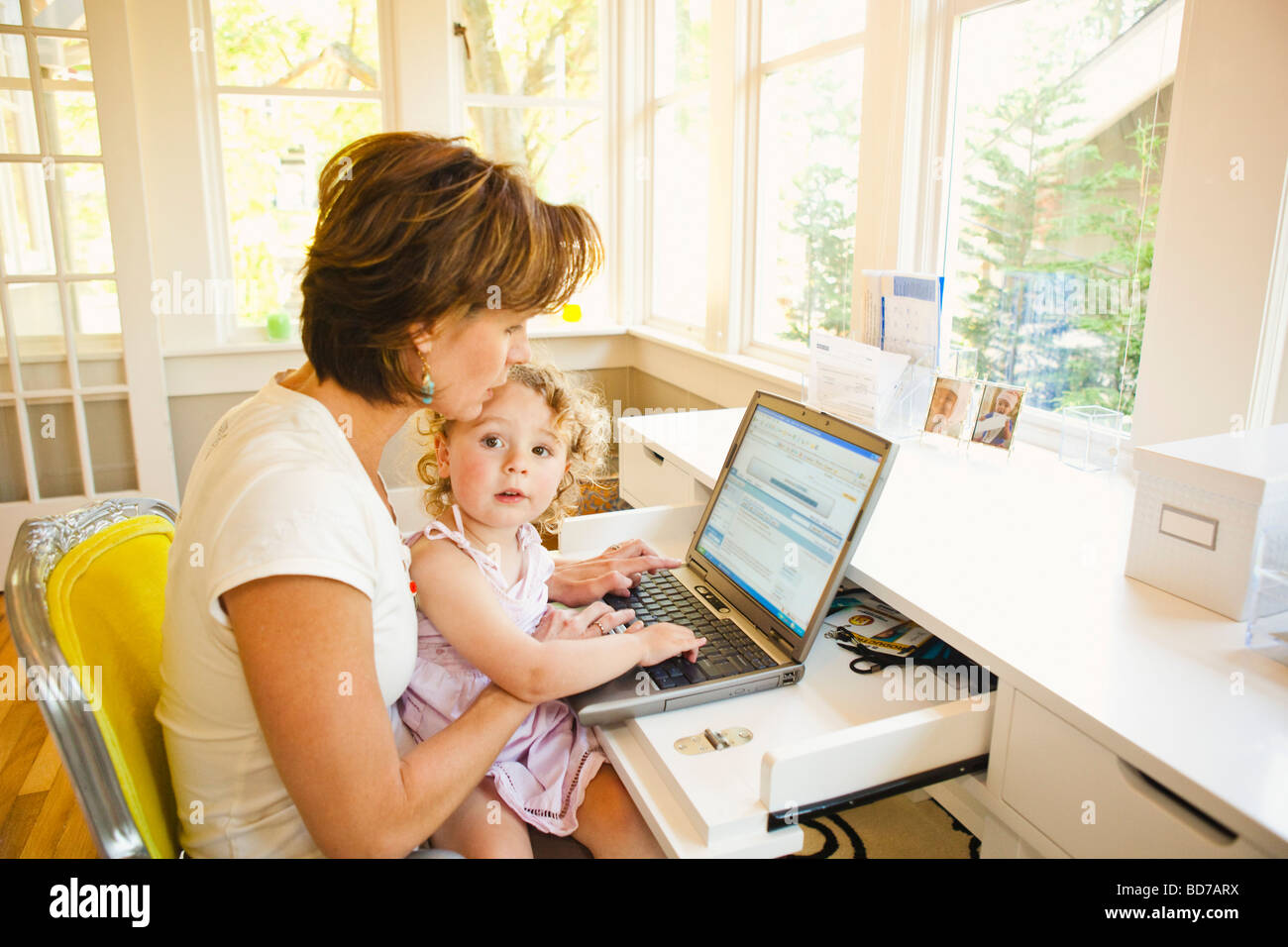 Woman with young child in home office Stock Photo - Alamy