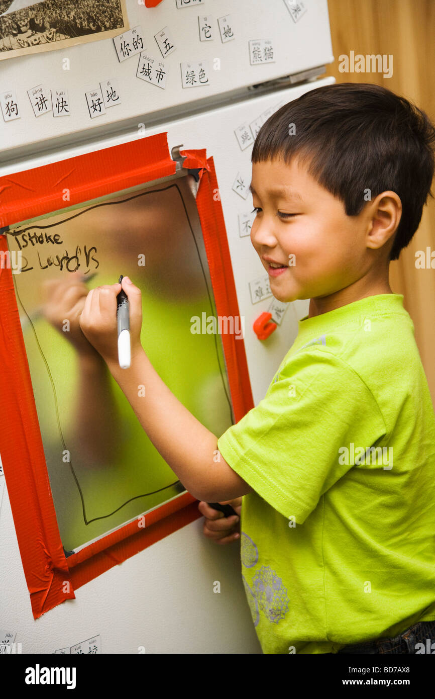 Boy writing on kitchen memo board Stock Photo - Alamy