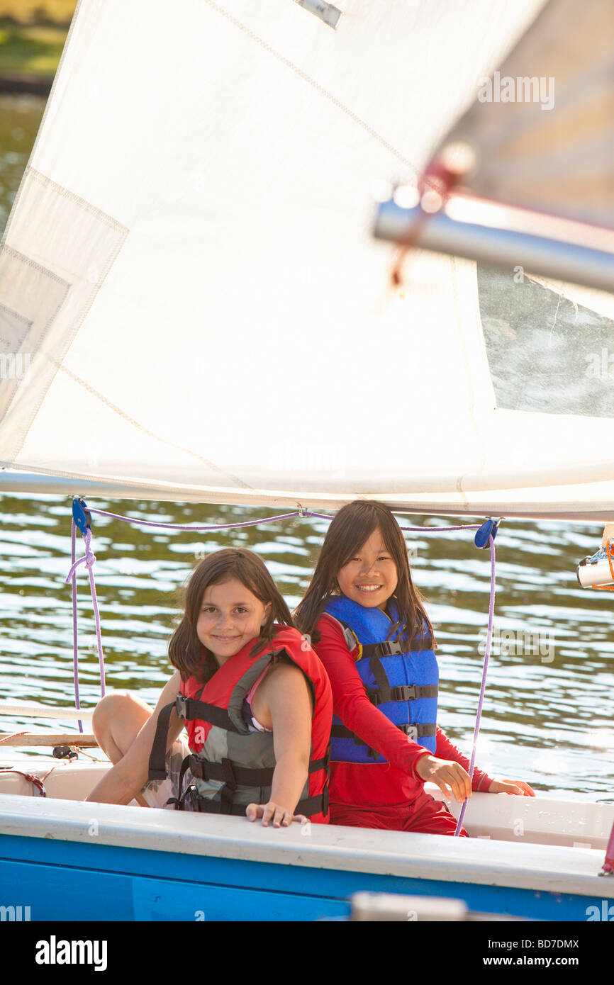 Two girls sailing small boat Stock Photo - Alamy