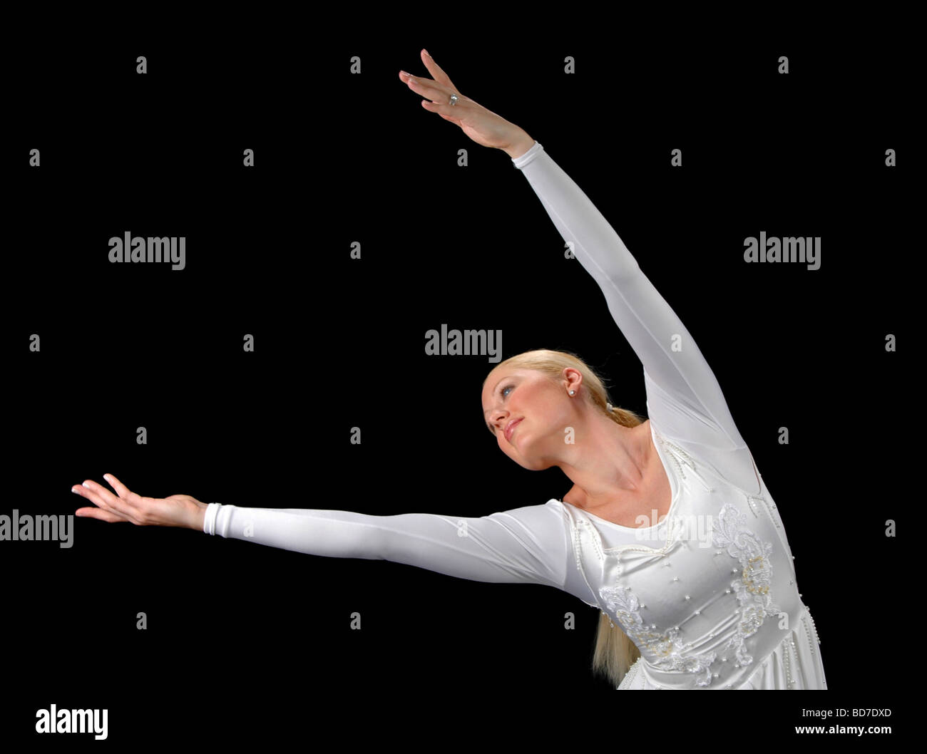 Ballet dancer dressed in a fancy gown performs over a black background ...