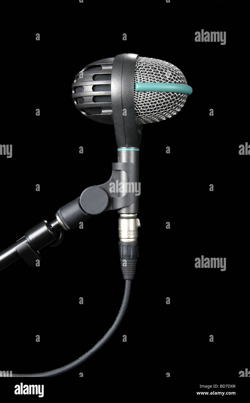 Microphone on stand isolated over a black background Stock Photo - Alamy