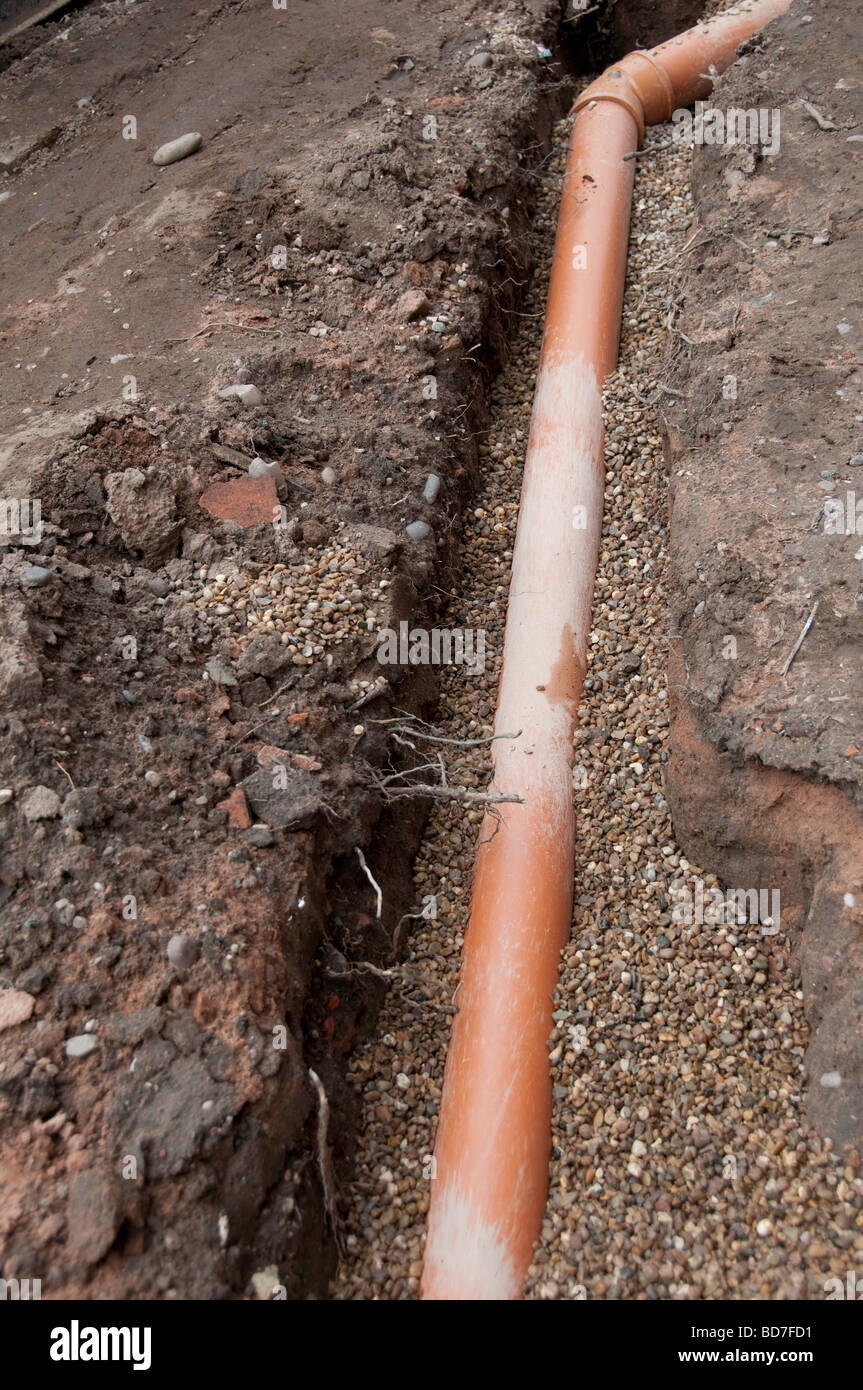 New plastic drains laid in bed of pea gravel before being backfilled ...