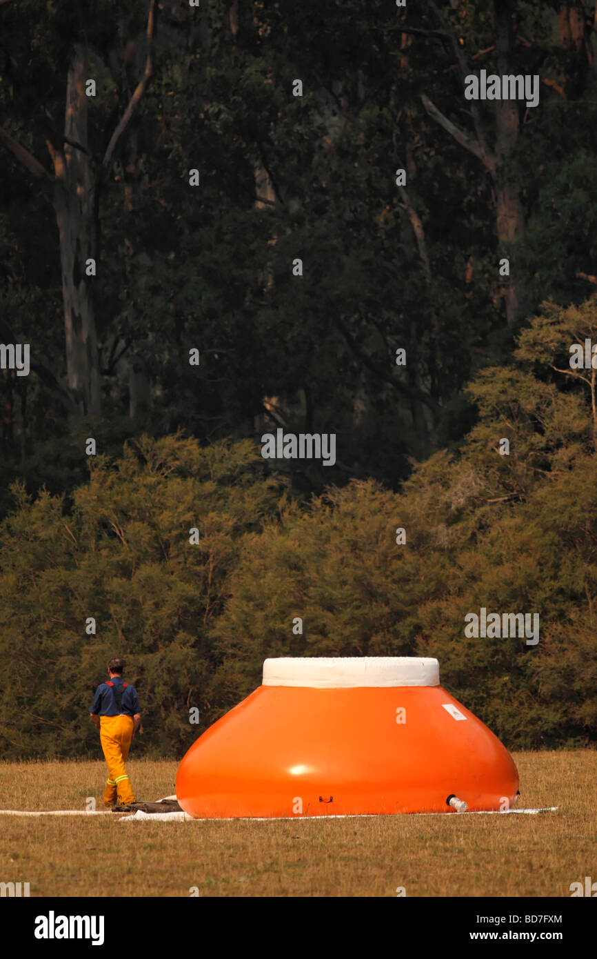 CFA fireman walking away from a collar fire fighting water storage tank ...
