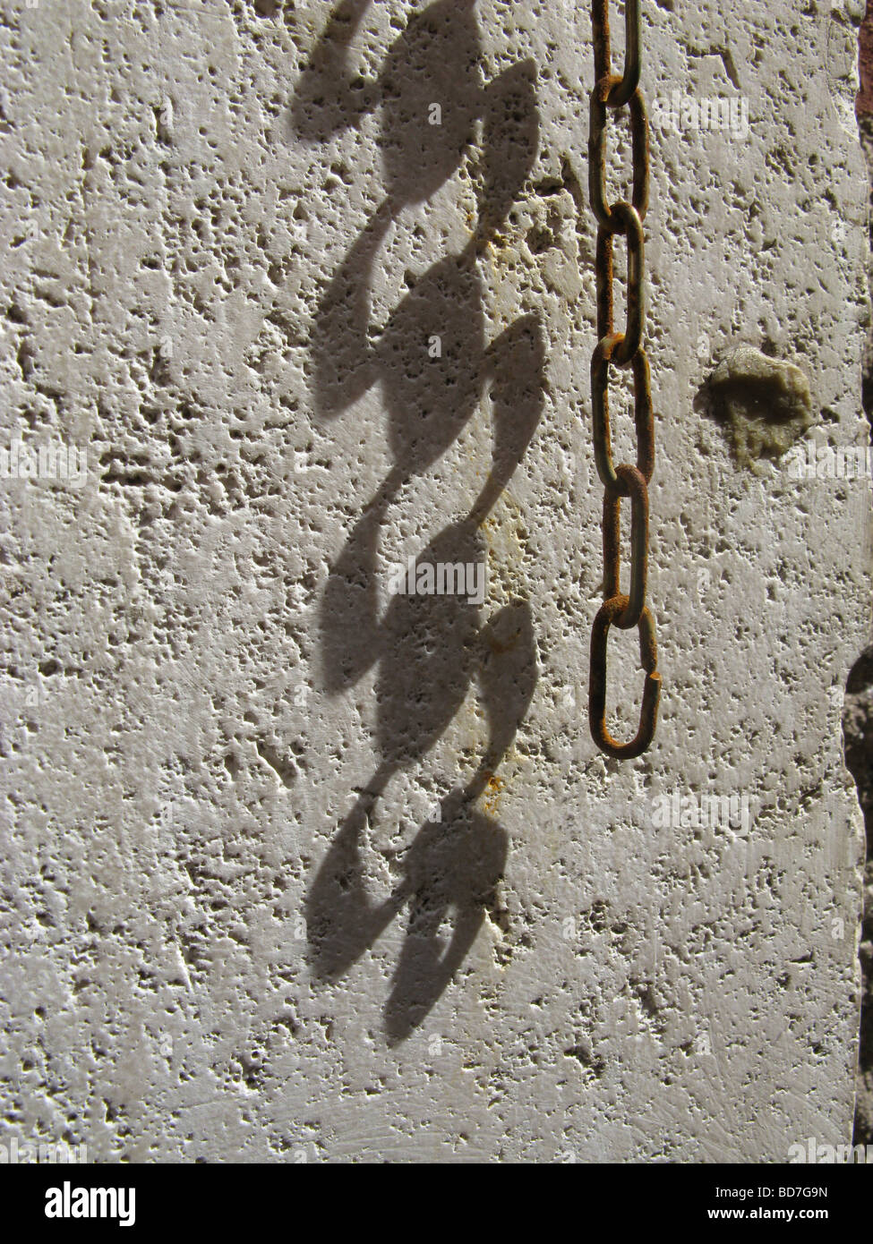 old rusty hanging chain by wall in sun Stock Photo - Alamy