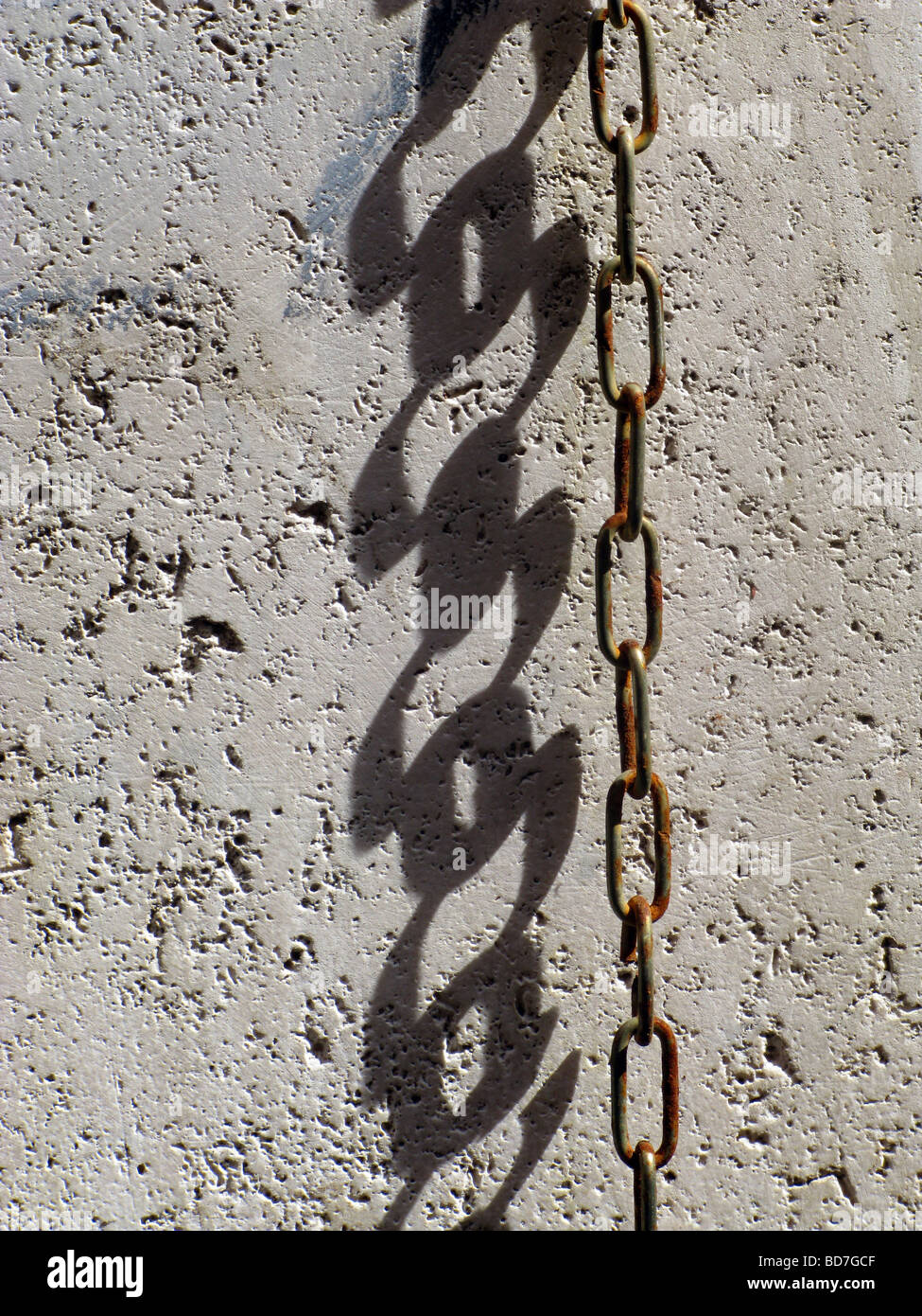 old rusty hanging chain by wall in sun Stock Photo - Alamy