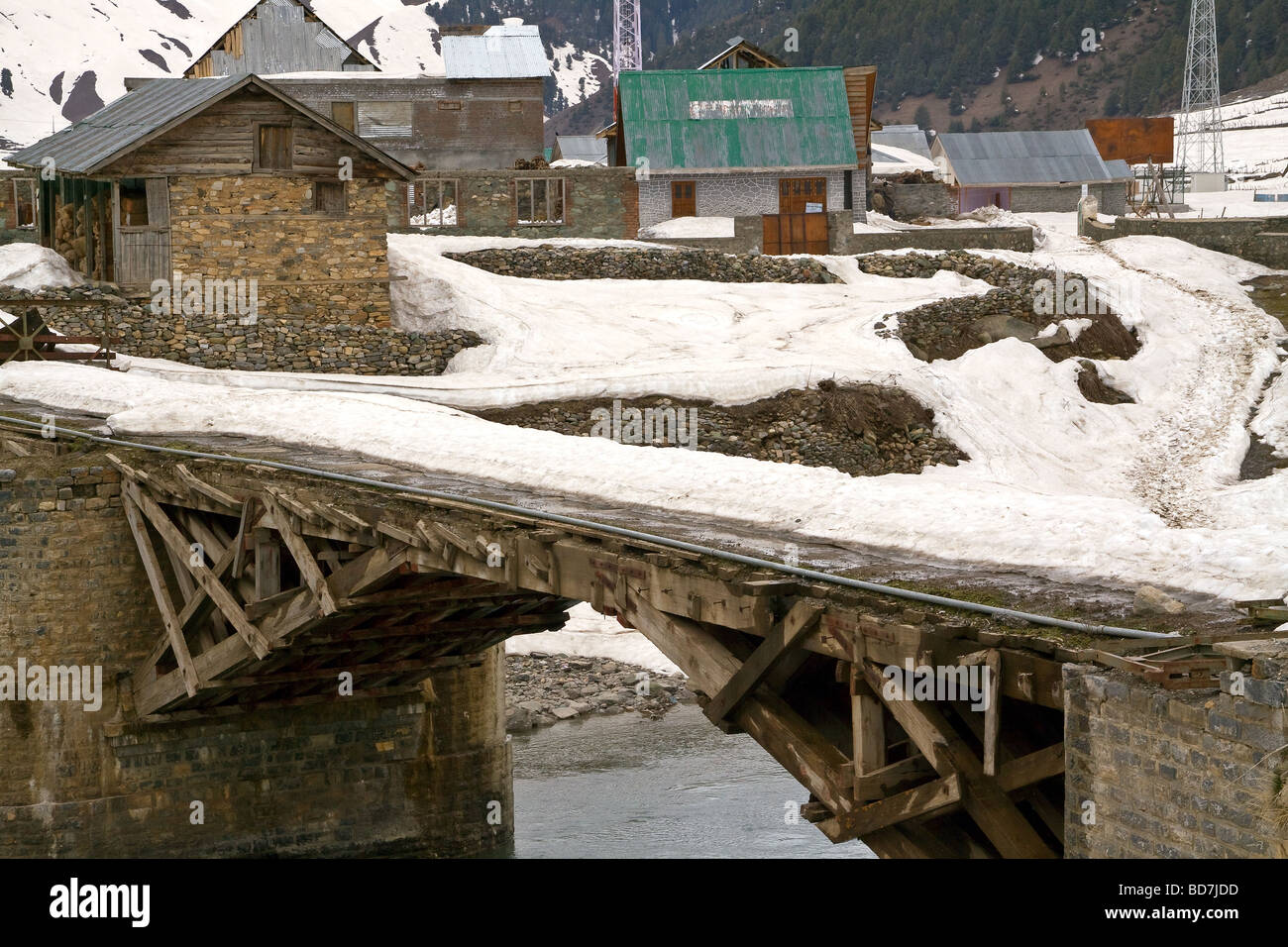 Old timber bridge spanning the river in the Himalayan village of ...