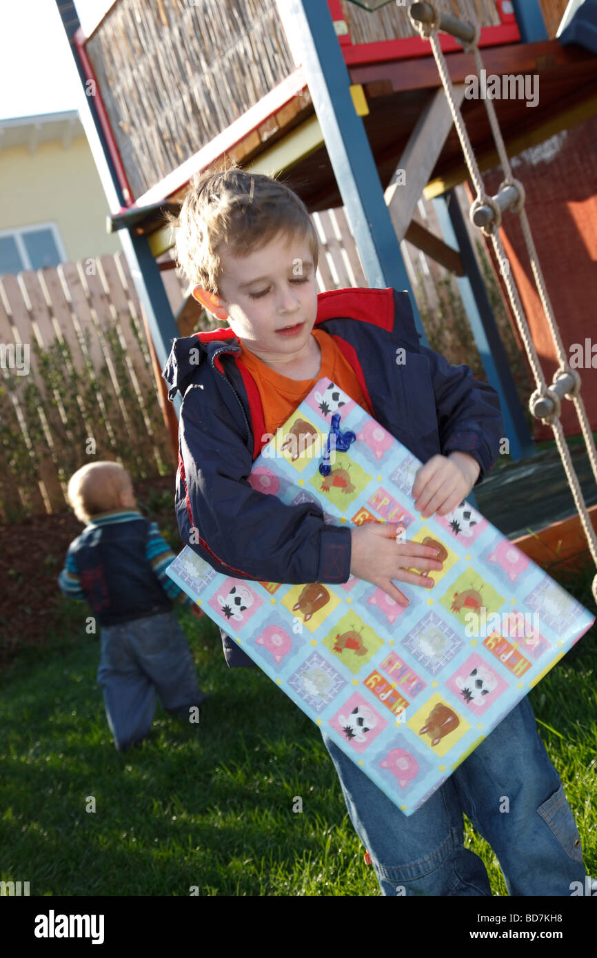little boy finding present in garden Stock Photo - Alamy