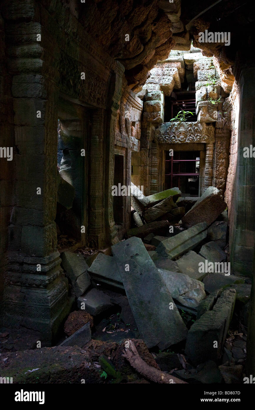 Deep shadows hide fallen blocks of stone inside the ruins of Ta Prohm ...