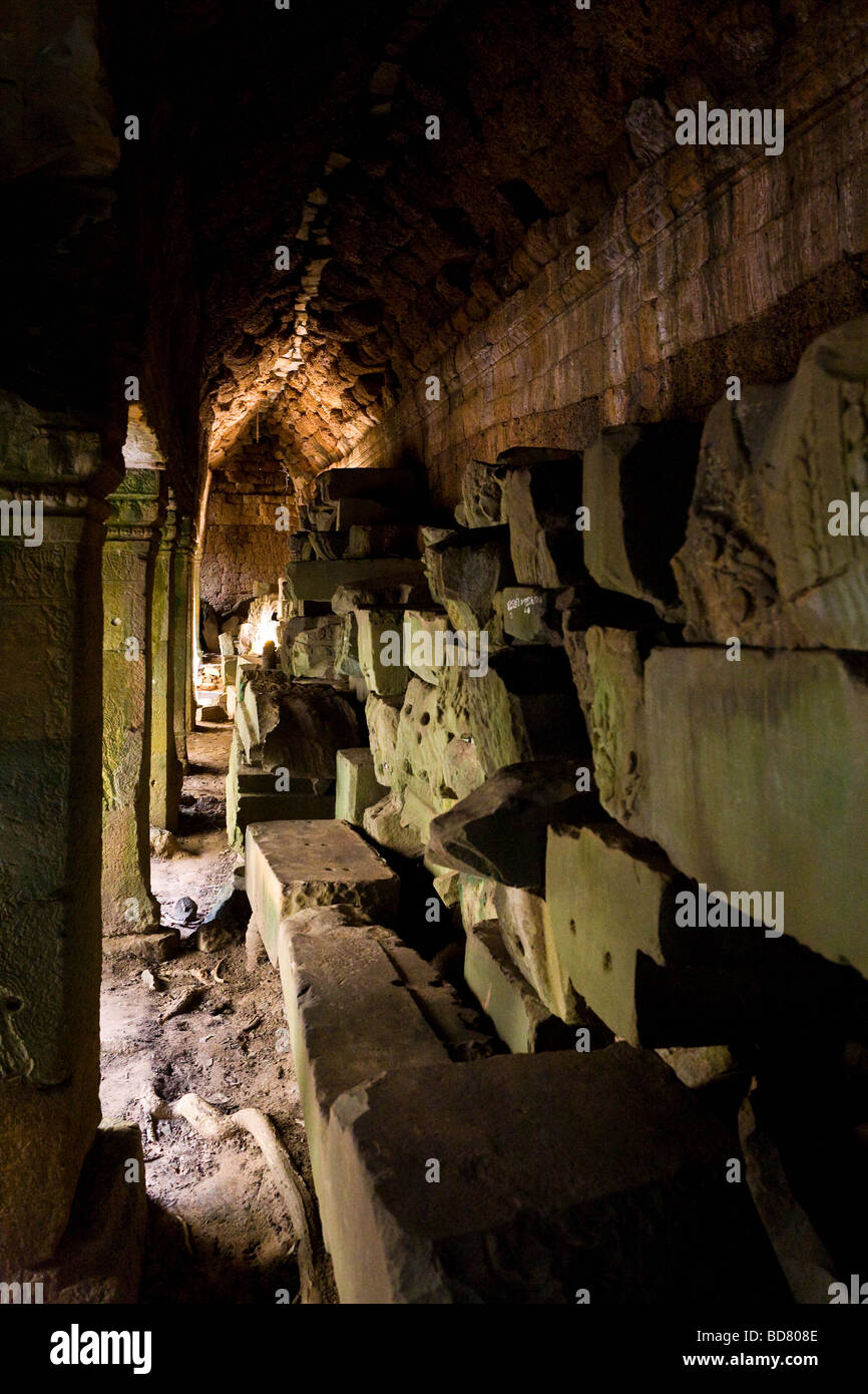 Deep shadows hide fallen blocks of stone inside the ruins of Ta Prohm ...