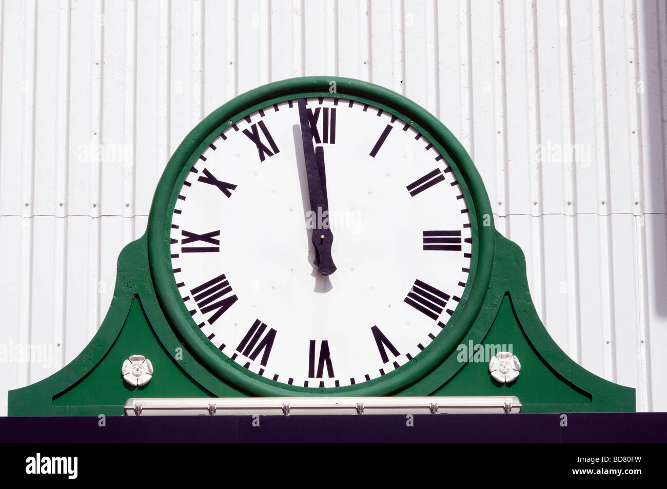 Large green and white restored "cricket pavilion" clock displaying "one ...