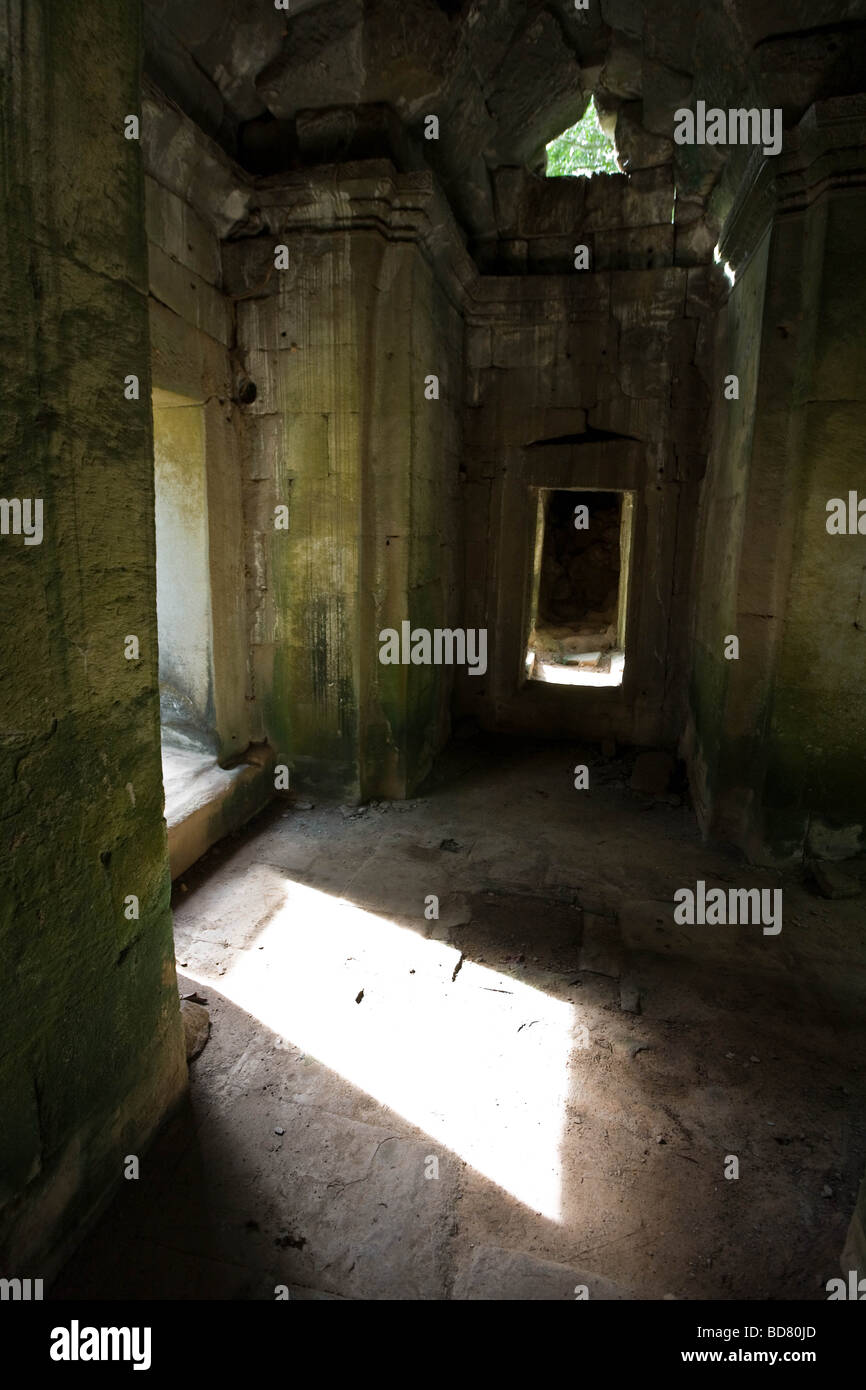 Bright sunlight illuminates a square inside an intact temple at Ta ...