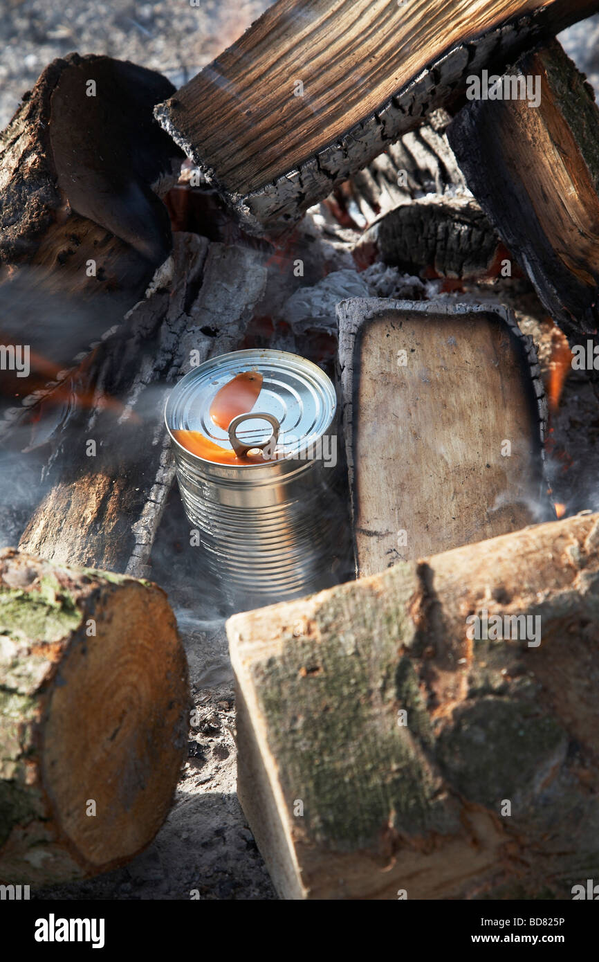 A tin of baked beans being heated in a campfire Stock Photo - Alamy