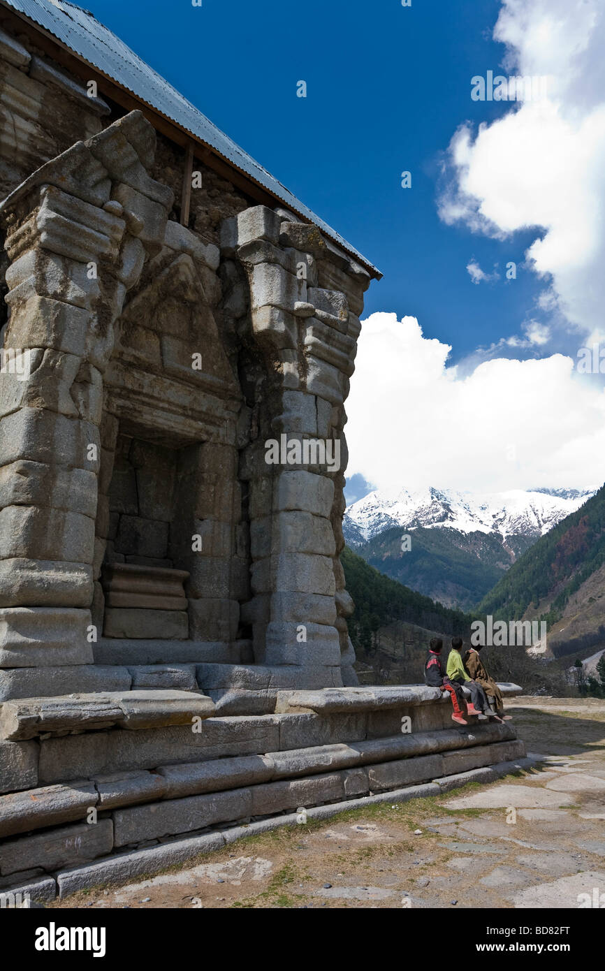 Children on the pediment of an ancient ruined temple in the Himalayas ...