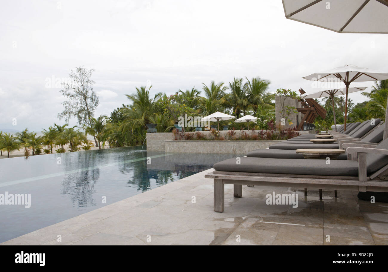 Deck chairs by swimming pool resort Stock Photo - Alamy