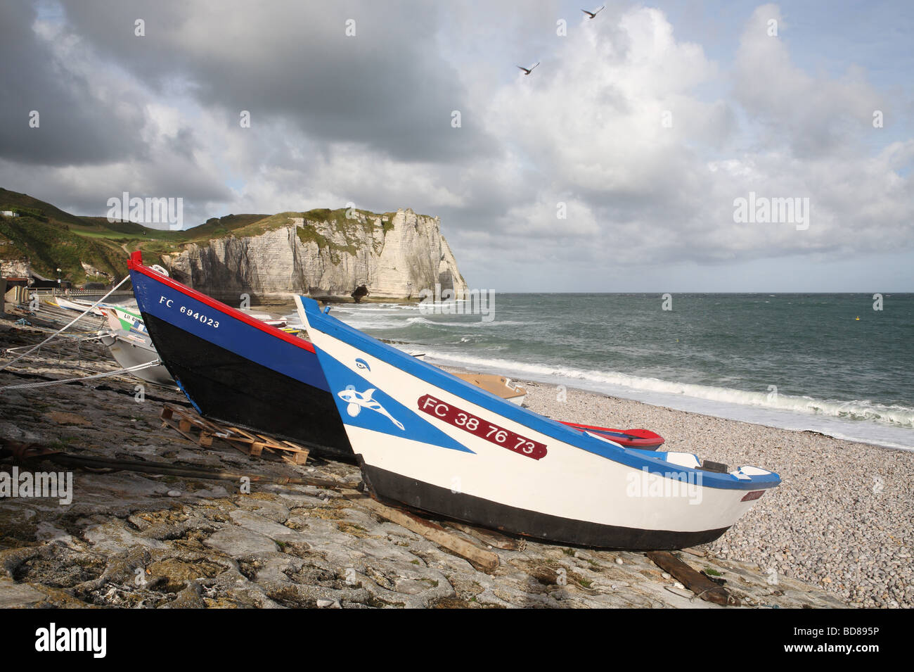 Fishing boats on the beach at Etretat in Normandy with the cliffs and ...