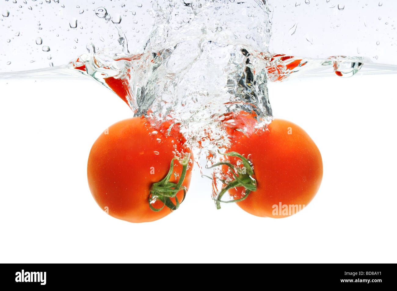 Red tomatoes splashing underwater Stock Photo - Alamy