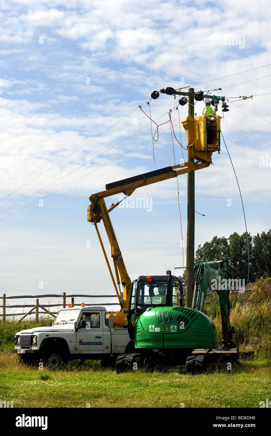 A workman on a cherry picker takes down some power lines near Upper ...