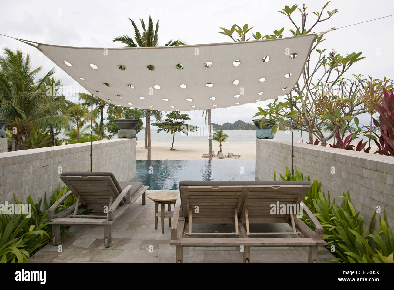Deck chairs by swimming pool resort Stock Photo - Alamy