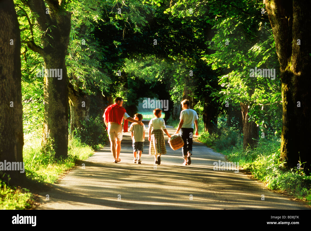 Family of four on country road enjoying summer picnic in Bavaria ...