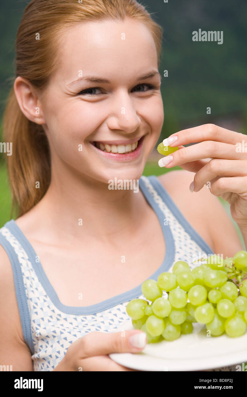 Young woman eating grapes Stock Photo - Alamy