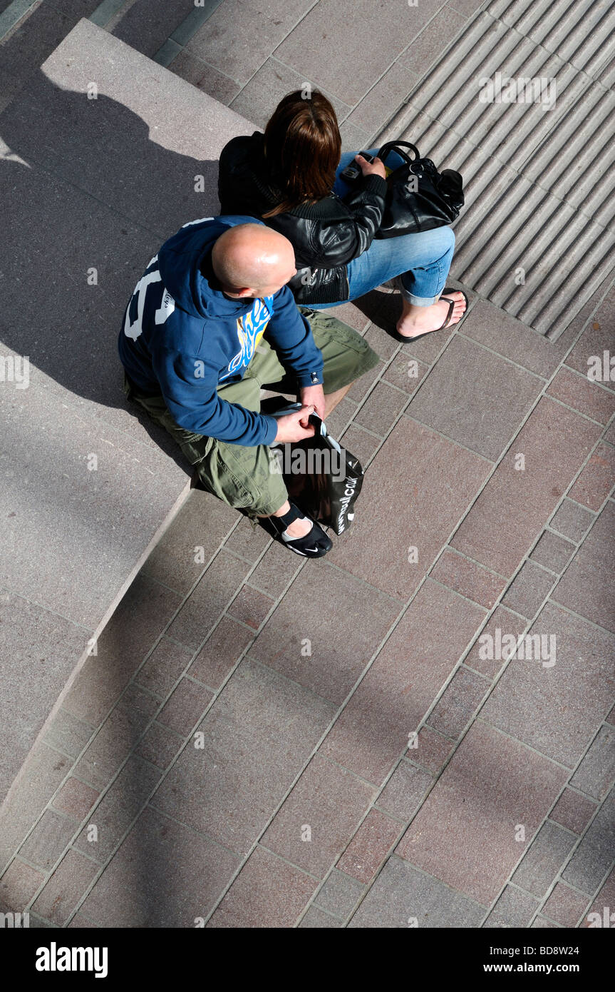 Two people sitting on stone bench view from above Stock Photo - Alamy