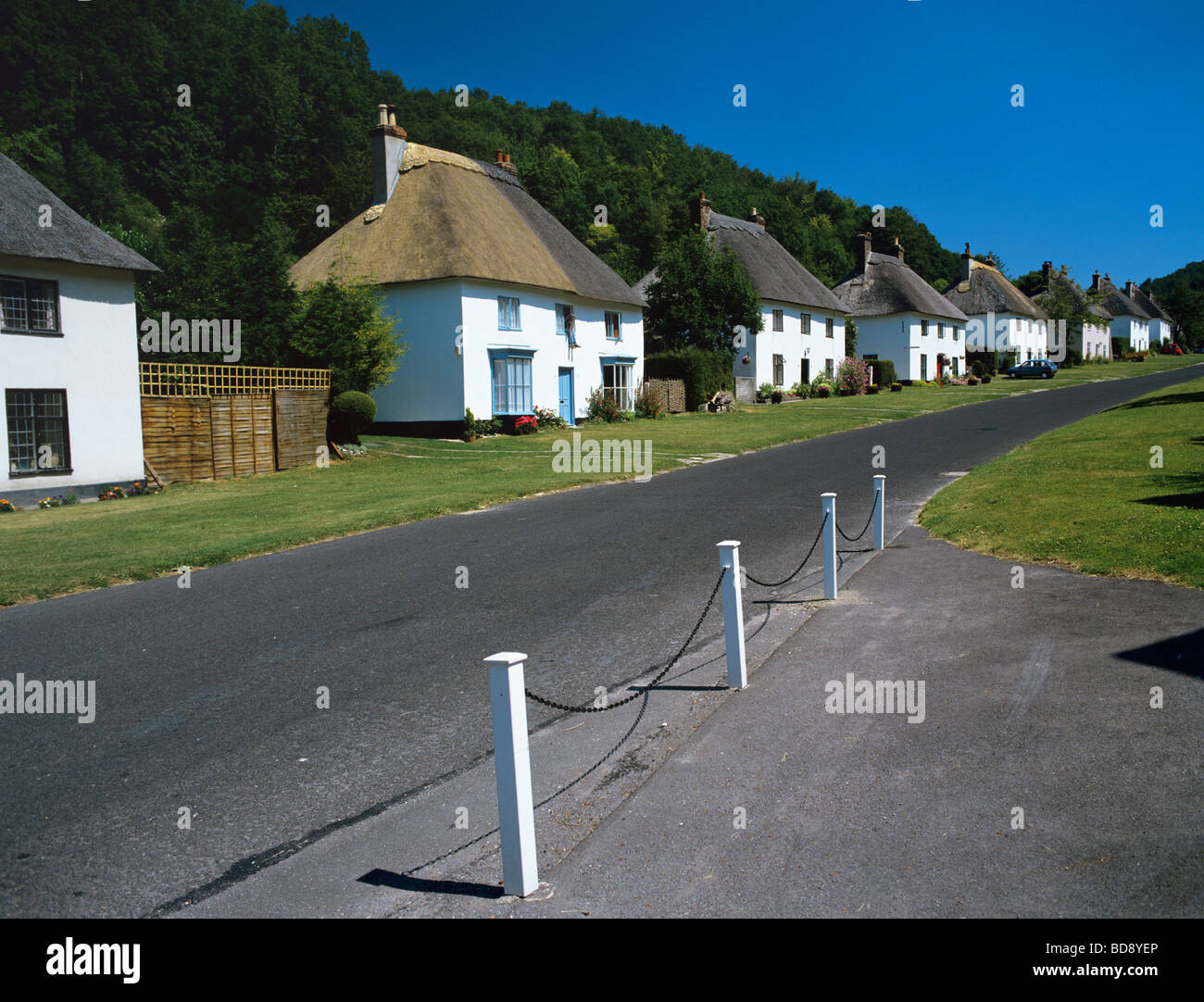 Row of white-washed thatched cottages line the main street through the ...