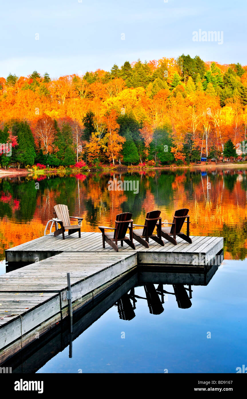 Wooden dock with chairs on calm fall lake Stock Photo - Alamy