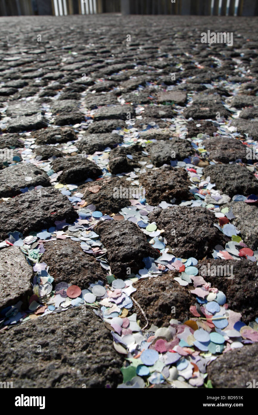lots of colourful confetti and garlands on paved street road in sun ...