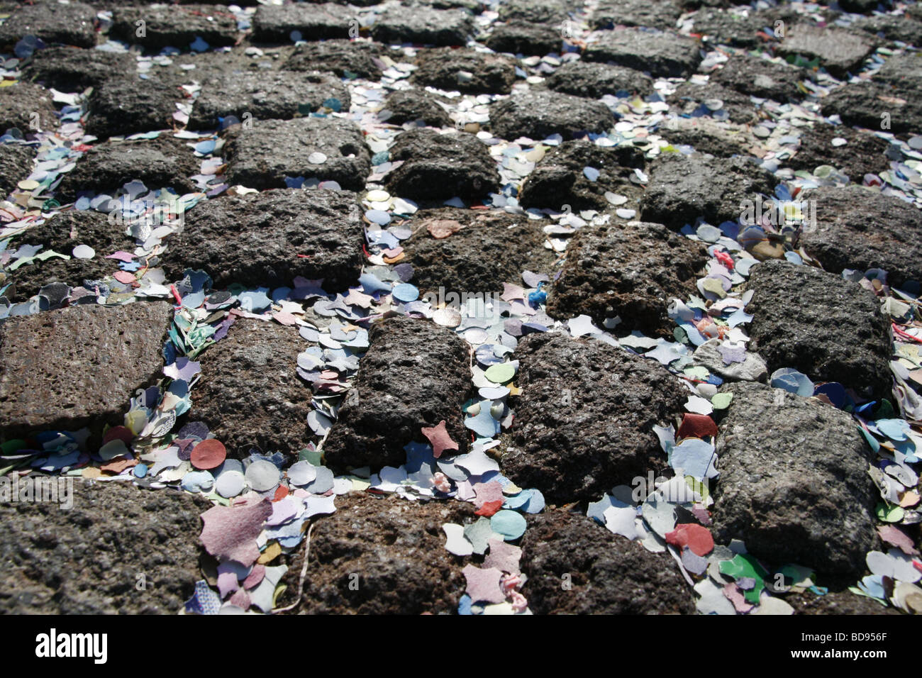 lots of colourful confetti and garlands on paved street road in sun ...