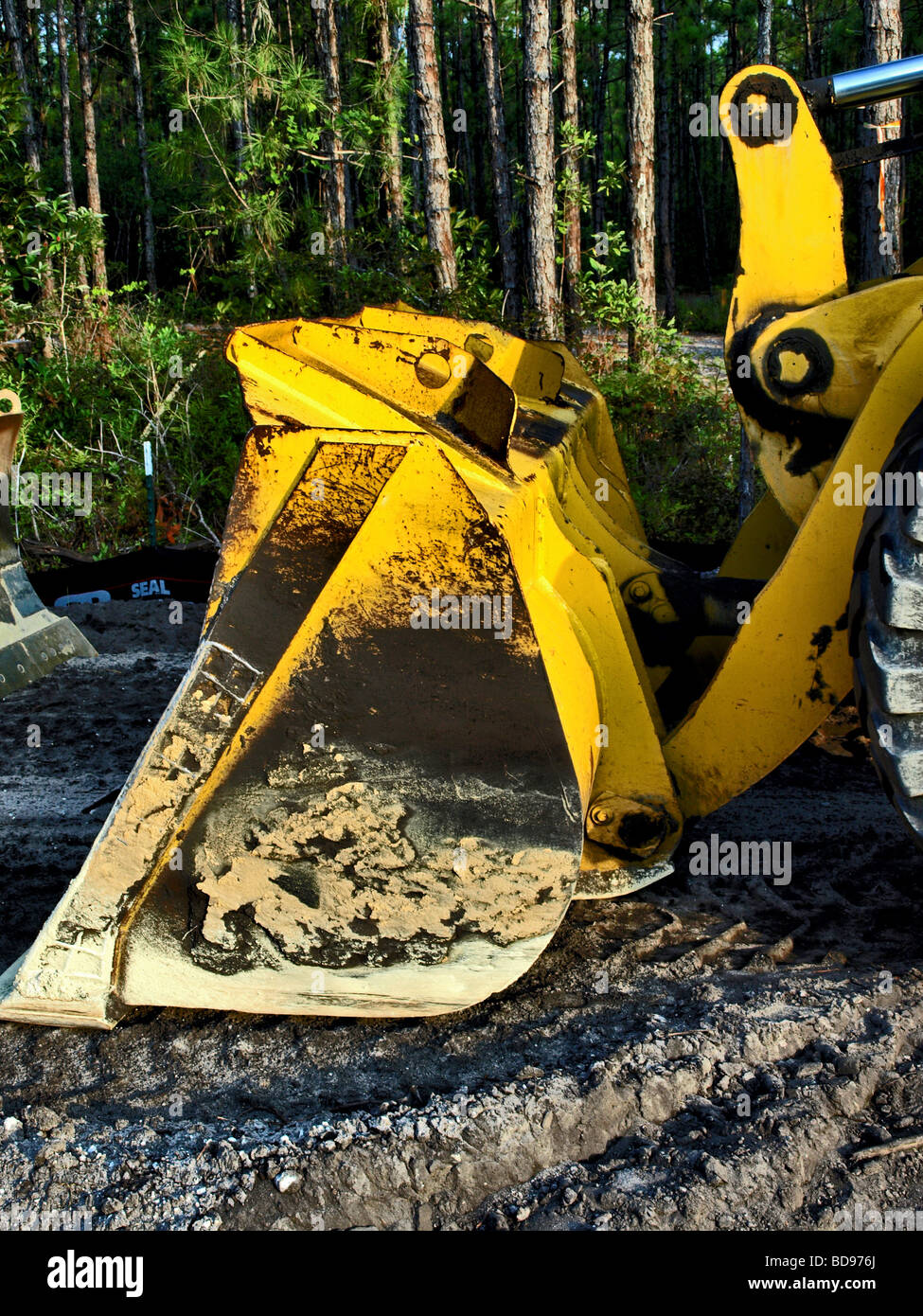 front end loader shovel in yellow at construction site with dirt on the ...
