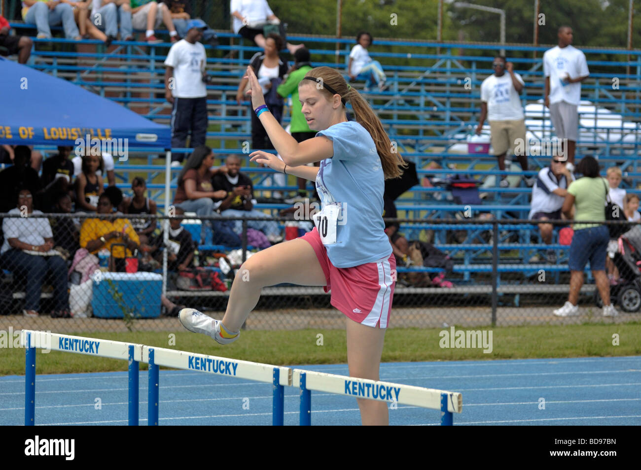 Female runner jumping over a hurdle at the Track and Field event during ...