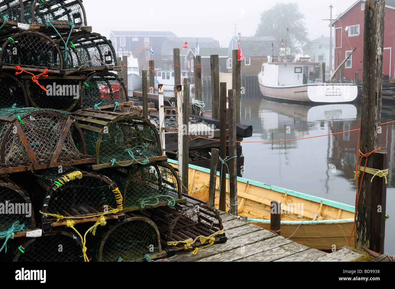 Wood lobster traps on dock and fishing boats in fog at Fisherman's Cove ...