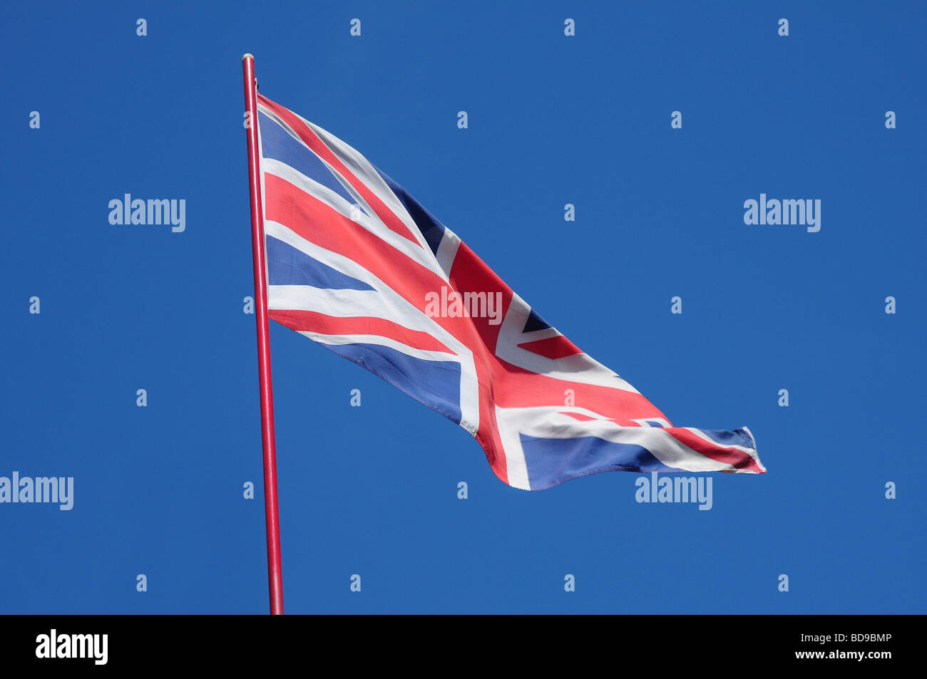 British Union Jack fluttering in a bright blue sky Stock Photo - Alamy