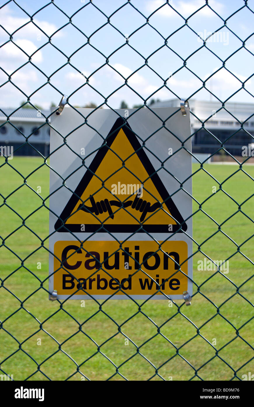 caution barbed wire sign on a fence at chiswick polytechnic stadium ...