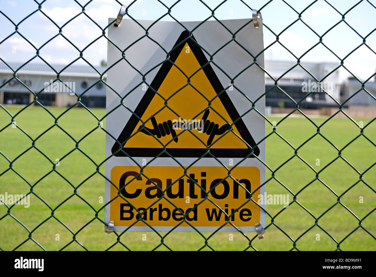 caution barbed wire sign on a fence at chiswick polytechnic stadium ...
