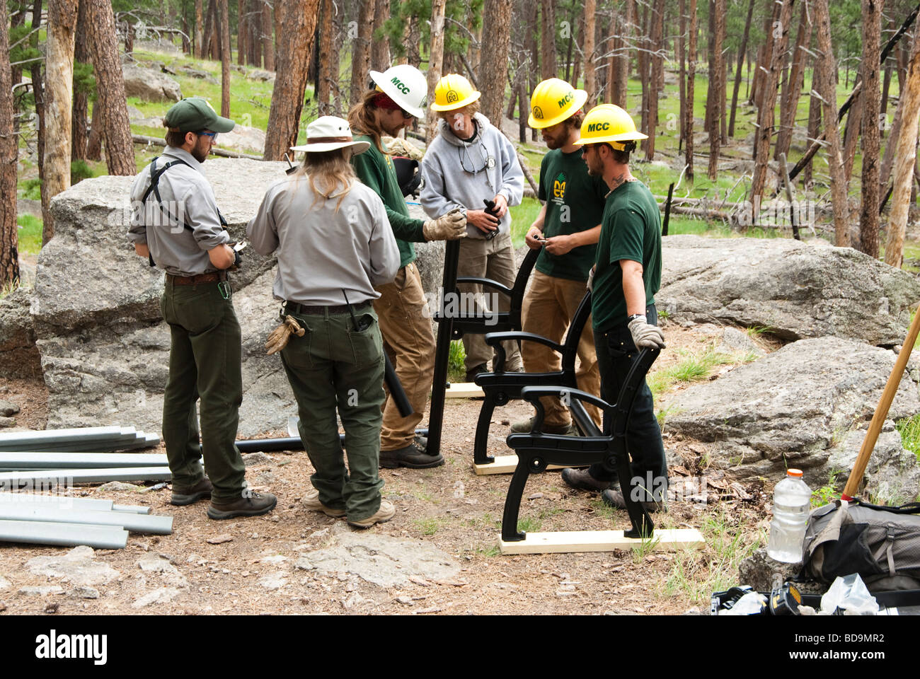 workers assembling a bench along a trail in Devils Tower National ...