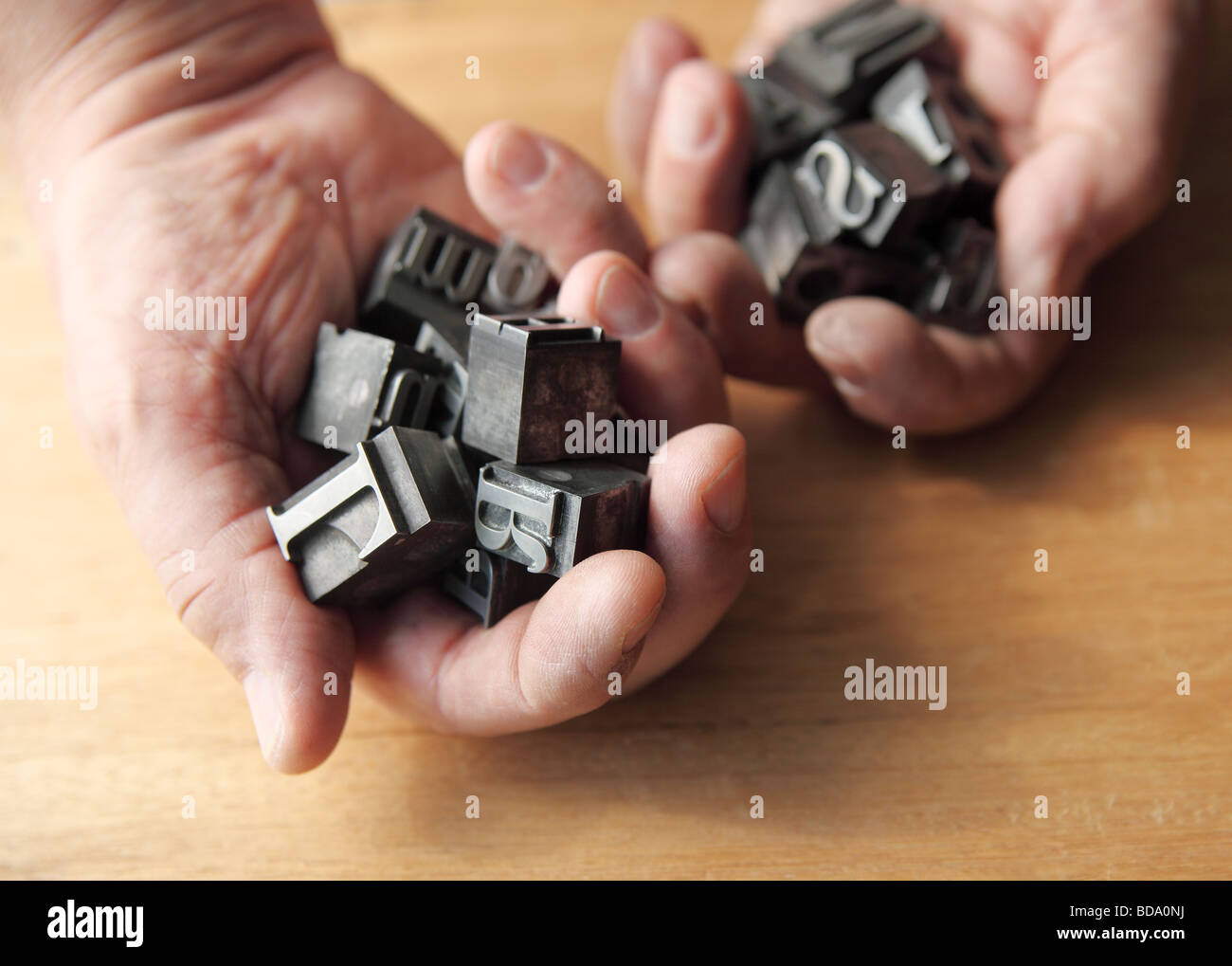 printer's ink-stained hands holding lead type pieces Stock Photo - Alamy