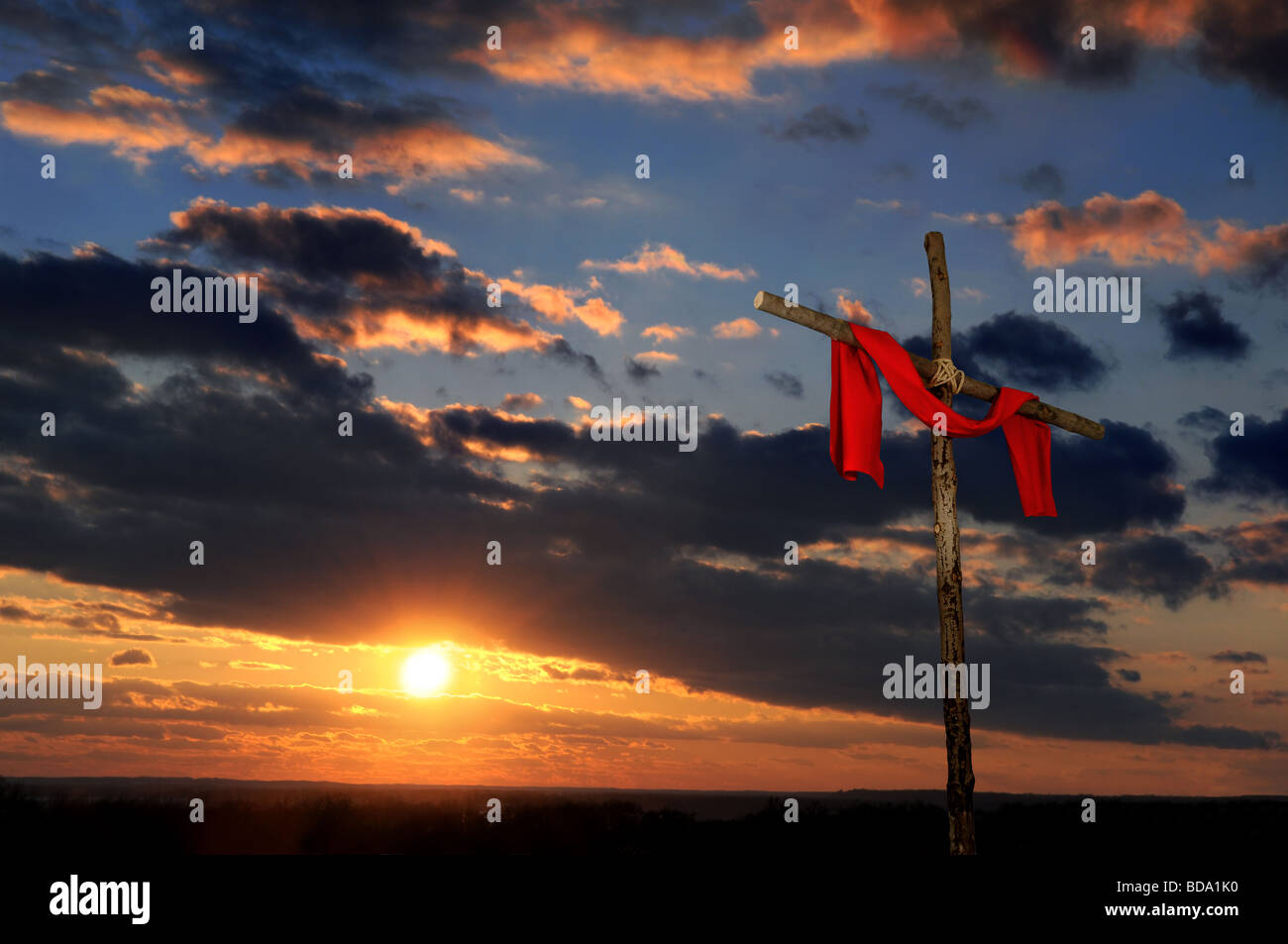 Cross with red tunic over a colorful landscape Stock Photo - Alamy