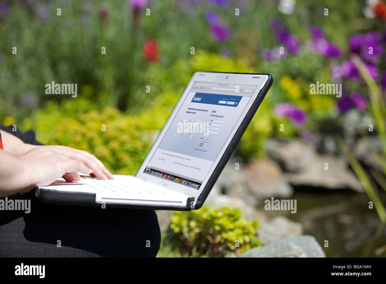Female using laptop showing social networking Facebook splash screen ...