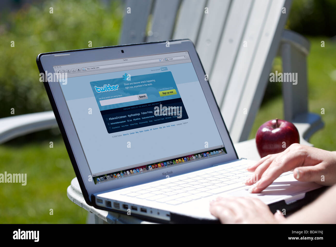 Female using laptop showing social networking Twitter splash screen ...