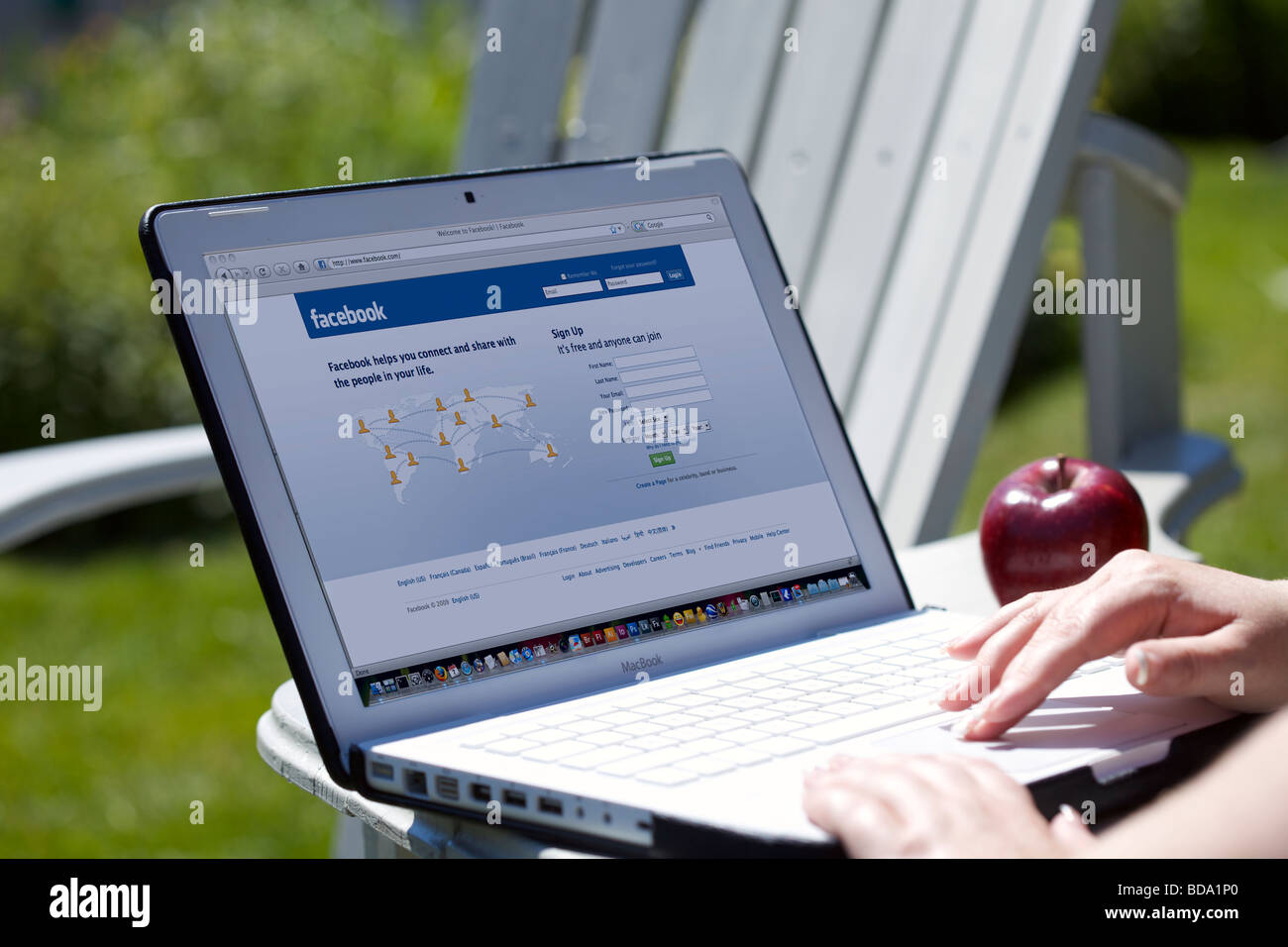 Female using laptop showing social networking Facebook splash screen ...