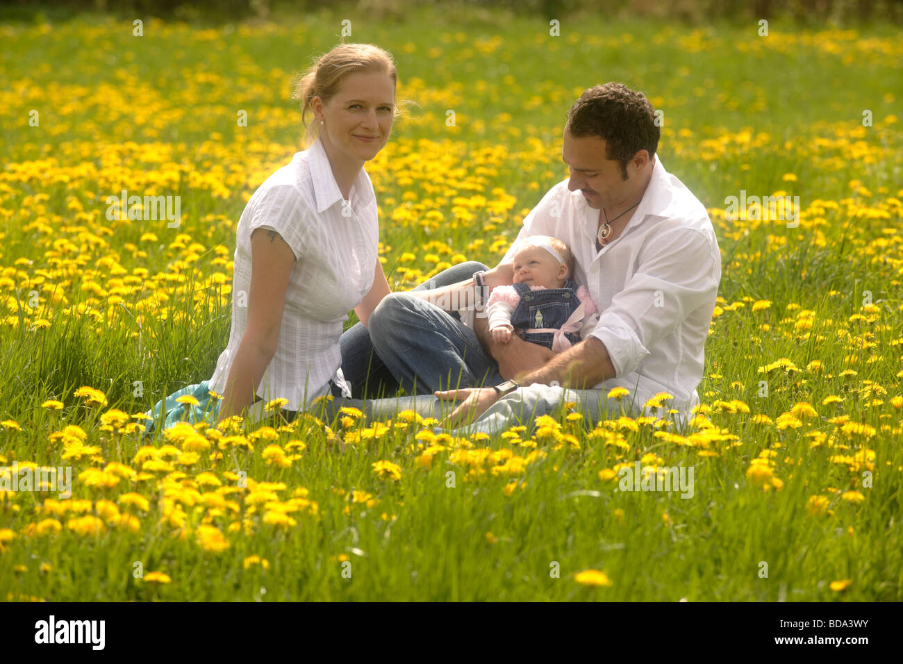 Family with a baby girl in a spring meadow Stock Photo - Alamy