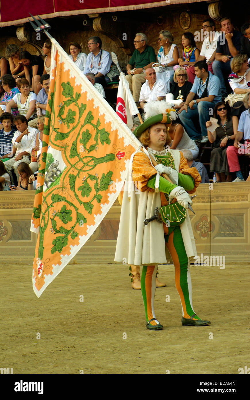 A standard bearer of the forest selva contrada in the Siena Palio, a ...