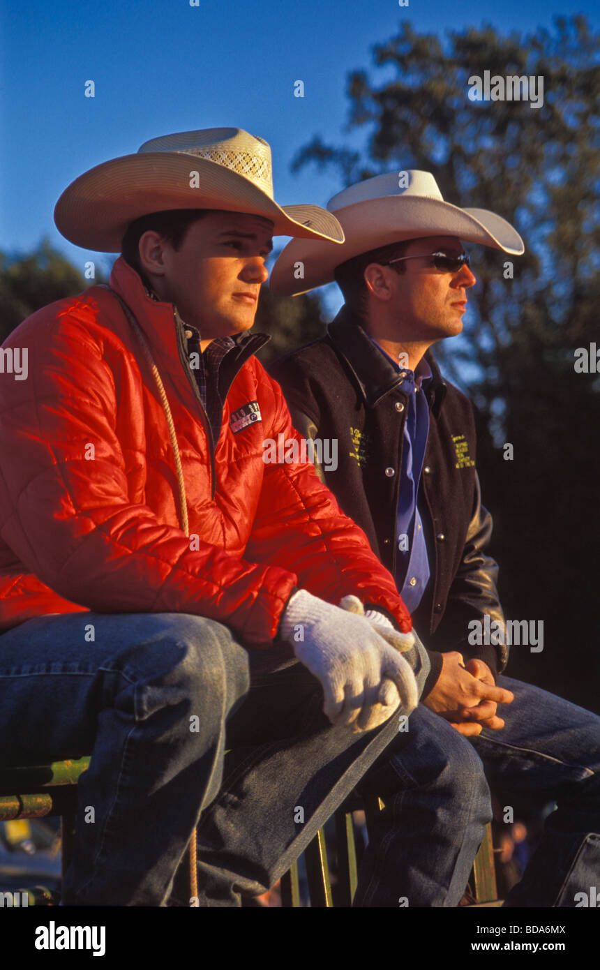 Two cowboys sit on fence overlooking rodeo arena Stock Photo - Alamy