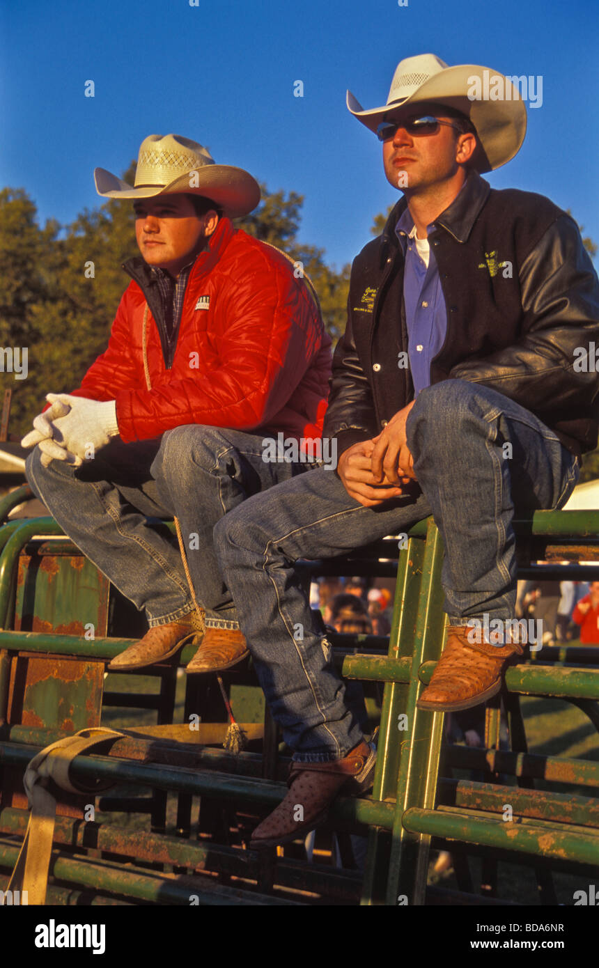 Two cowboys sit on fence overlooking rodeo arena Stock Photo - Alamy