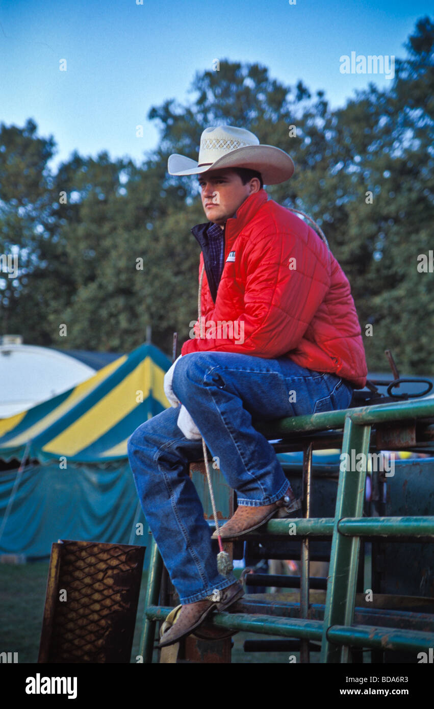 Young cowboy sits on fence overlooking rodeo arena Stock Photo - Alamy