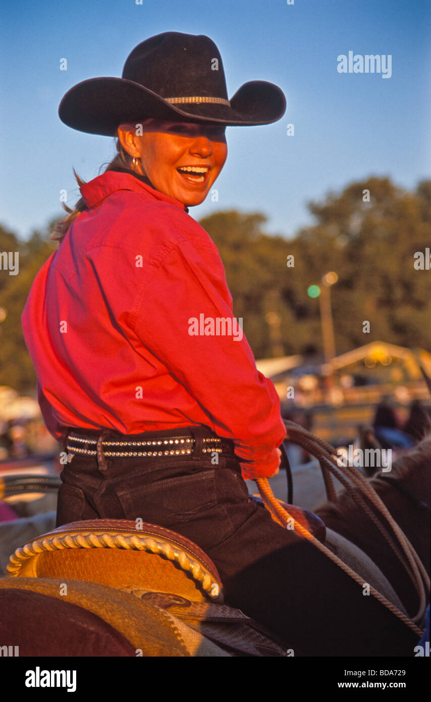 Smiling cowgirl saddles up at county fair rodeo Stock Photo - Alamy