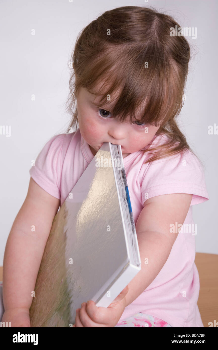 Child in Pink Sitting with a plain background Stock Photo - Alamy