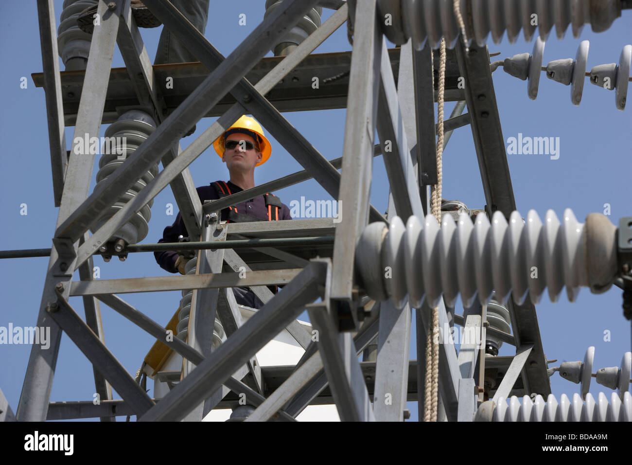Portrait of a utility workman wearing safety harness and hardhat ...