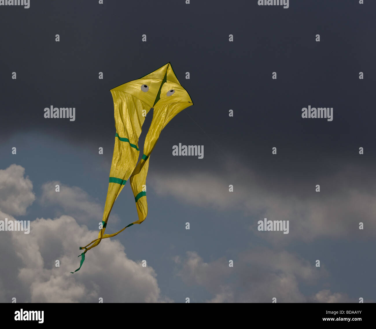 Giant Yellow Kite Flying in a stormy dramatic black sky over Blackheath ...